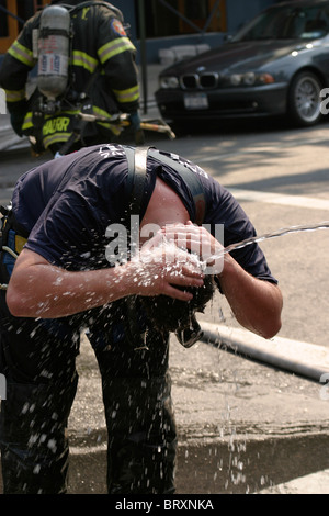 Fireman cooling down a fire truck at an industrial fire Stock Photo - Alamy