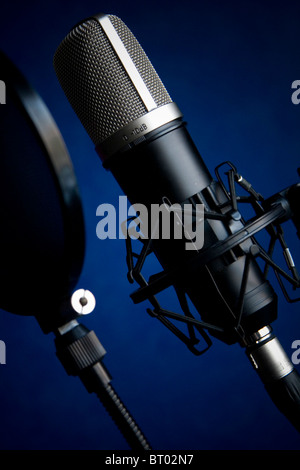 A condenser microphone with shock mount and pop shield in a desk stand ...