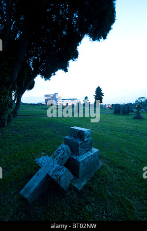 A fallen gravestone in a cemetery at night overlooking the John ...
