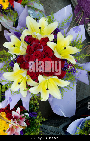 A closeup shot of rose-scented square soap on a wooden stand surrounded ...