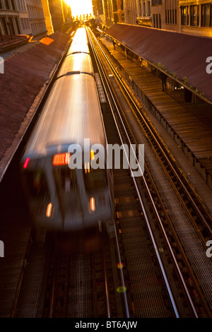 Sunrise illuminates a train in the Chicago rapid transit system known ...