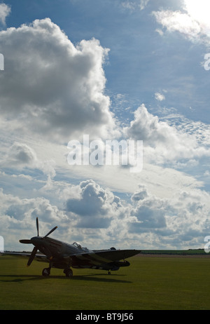 A WWII-era RAF Supermarine Spitfire fighter plane soars through a pale ...