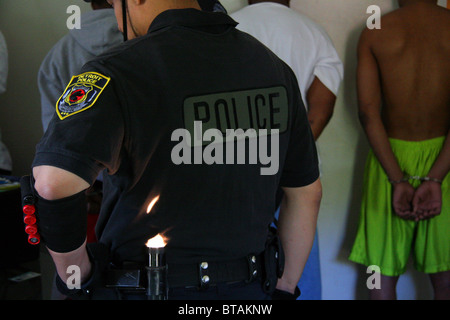 Police officer from the Detroit Police Narcotic unit with handcuffed ...