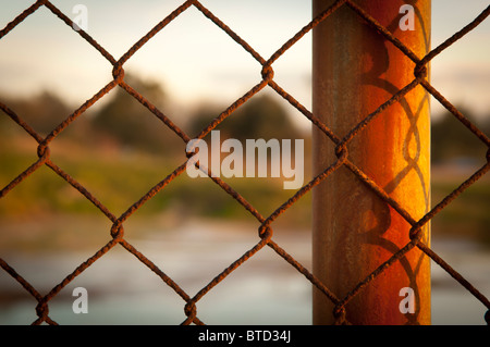 Cyclone mesh fence with rusty wire twist Stock Photo - Alamy