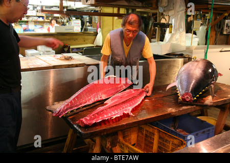 Japanese fishmongers cutting a blue fin tuna in Tsukiji fish market in ...