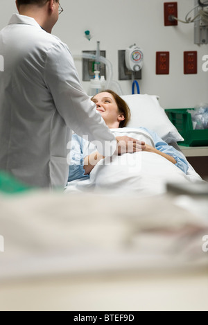 Doctor reassuring patient lying on hospital gurney Stock Photo - Alamy
