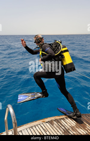 Scuba diver jumping into the water from a dive boat.Coastal waters ...