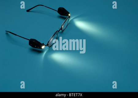 Reading eyeglasses with small lights attached to the frames. Light is ...