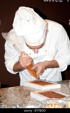 A chef pours chocolate into trays to make Lindt chocolates, " Salon du ...