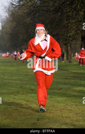 Happy Santa Claus running a race on an asphalt road at the finish line ...