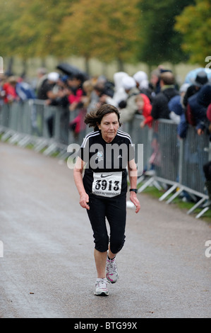 Woman running in the rain at the Windsor Great Park half marathon in ...