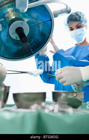 Surgeon Handing Surgical Instrument to Assistant in Operating Room ...