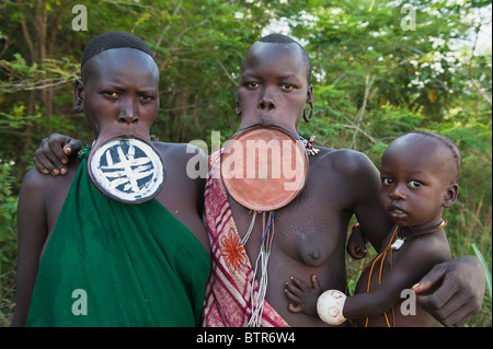 Two Surma women with huge rounded lip plates and holding a baby, Kibish ...
