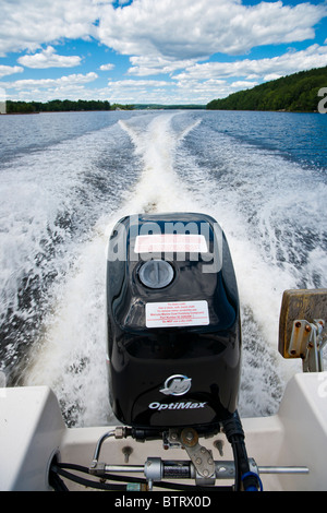 A Mercury Optimax outboard motor powers a speedboat through the water ...