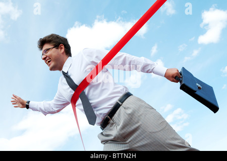Photo of happy businessman crossing finish line during race Stock Photo ...