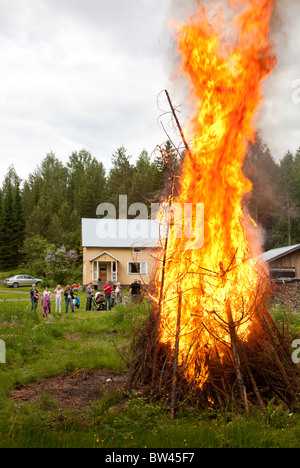 People watching midsummer pyre burning , Finland Stock Photo - Alamy