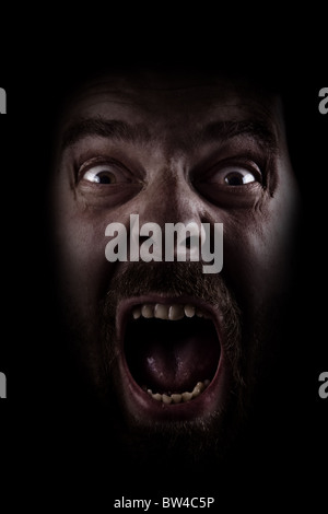 Scared face of spooky man in the dark. The man is yelling Stock Photo ...