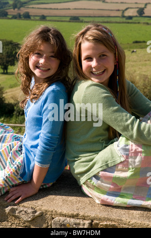 Two friends laughing back to back Stock Photo - Alamy