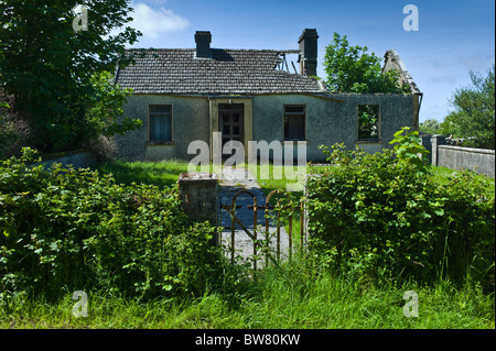 Derelict traditional period old stone cottage overgrown by wilderness ...
