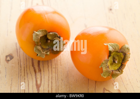 Persimmon fruit on wooden table with blurred garden background Stock ...