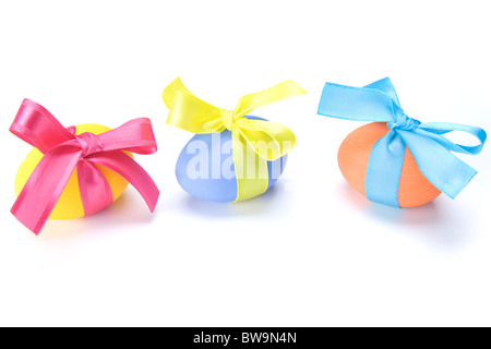 Image of three multicolored eggs tied by silk ribbons on white ...