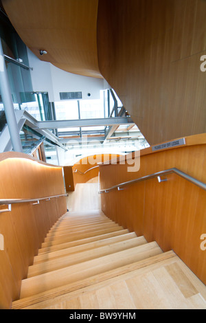 Looking down staircase at hall with wooden flooring and stained-glass ...