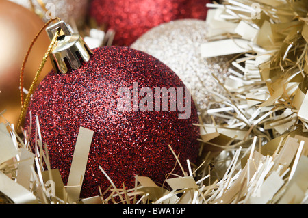 Silver, gold, and red baubles and string lights decorate a Christmas ...