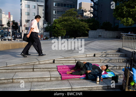 People walk past homeless man begging street in London England UK Stock ...