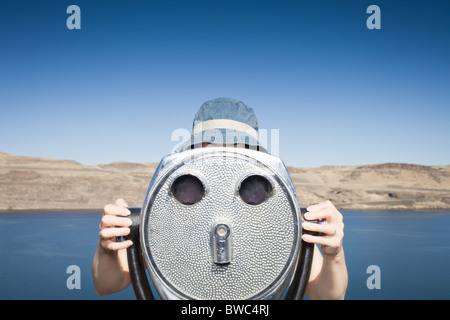 Woman using telescopic viewer Stock Photo - Alamy