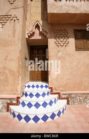 Coloured tiled steps leading to a wooden doorway in a moroccan town ...