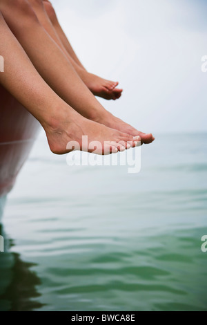 unrecognizable two people feet with white tennis shoes next to two ...