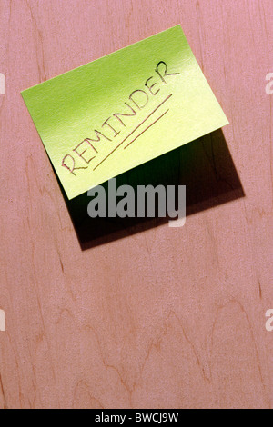 Reminder post it note stuck to wall Stock Photo - Alamy