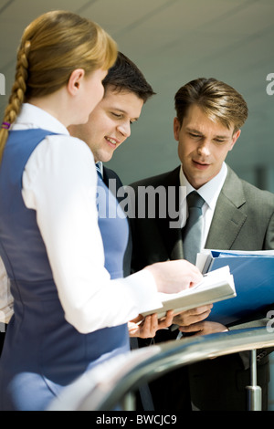 Confident businesswoman explaining to workgroup business plans in ...