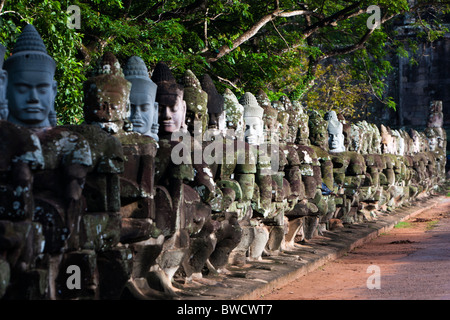 Stone sculptures border the bridge to the temple Angkor Thom in Angkor ...