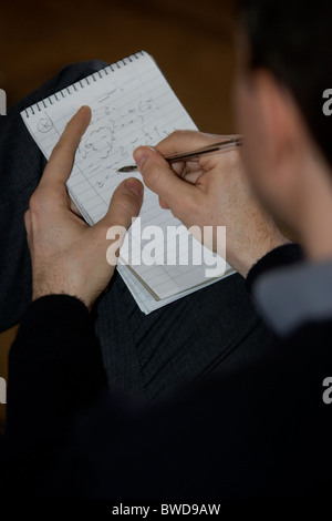 A reporter pictured writing in shorthand during an interview in Stock ...