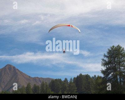 Parasailing in the blue sky near the beach. Paragliders flying high in ...