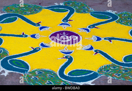 Sacred OM / AUM Rangoli coloured powder design in an Indian street ...