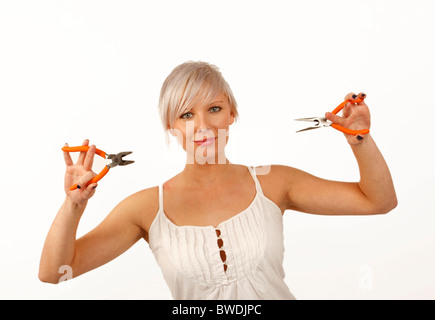 young woman holding pairs of pliers and wire cutters as part of an ...