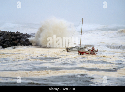 High waves crashing over rocks, rocking small boats, stormy seas on the ...