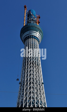 A low angle shot of cranes and construction sites against a cloudy sky ...