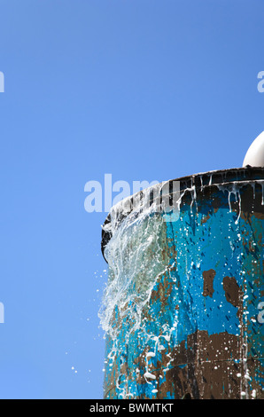 Water overflowing from industrial tank Stock Photo - Alamy