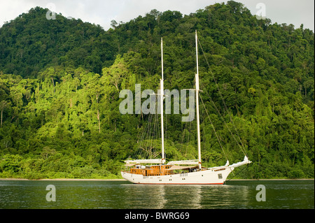 Scenic view of Batanta Island and a sailing boat, Raja Ampat Indonesia ...