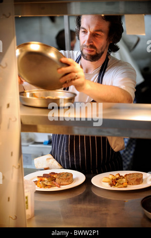 Head Chef Stephen Terry applies finishing touches to meals going out to ...