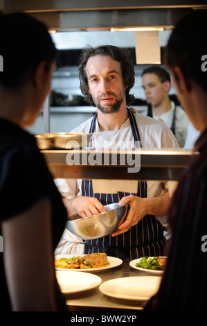 Head Chef Stephen Terry applies finishing touches to meals going out to ...