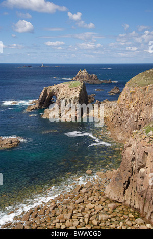 Rugged granite sea cliffs, with arch and blurred long exposure sea, on ...