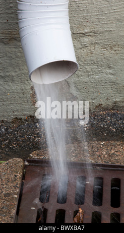 Downspout spewing water to drain Stock Photo - Alamy