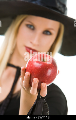 Evil witch holding a red apple Stock Photo - Alamy