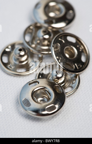 Close up of a group of metal Snap on Buttons on white background. Macro ...