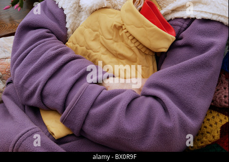elderly woman keeping warm in winter wrapped up with a fleece blanket ...