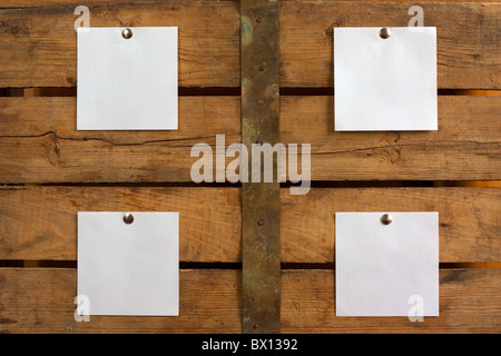 Four pieces of blank paper tacked to wooden background.Ready for your ...